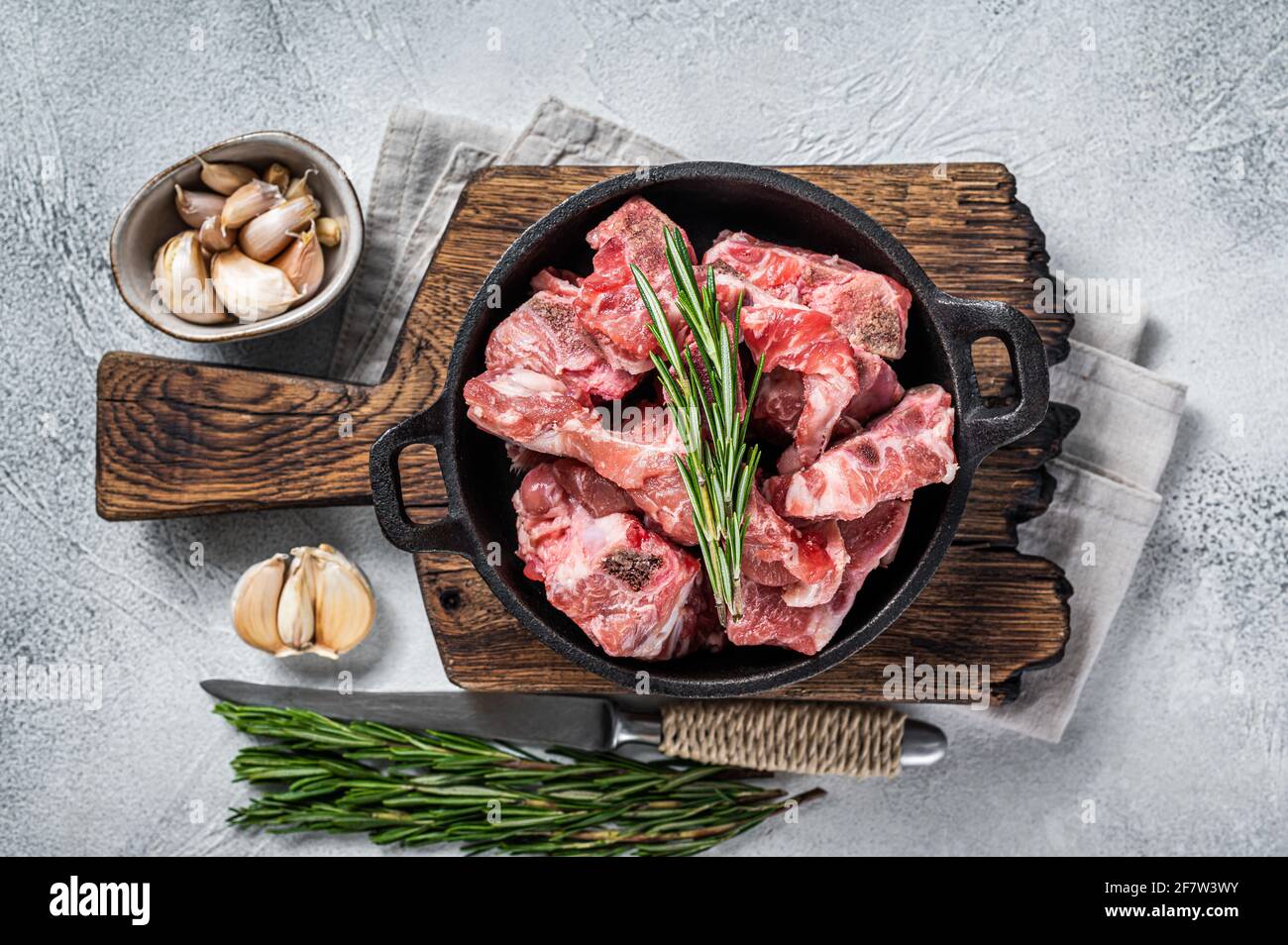 Raw diced meat cubes with bone in a pan. White background. Top View ...