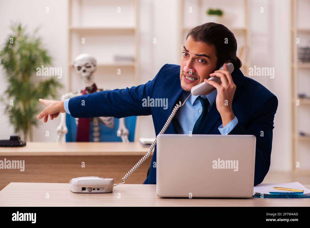 Dead employee working in the office in funny concept Stock Photo - Alamy