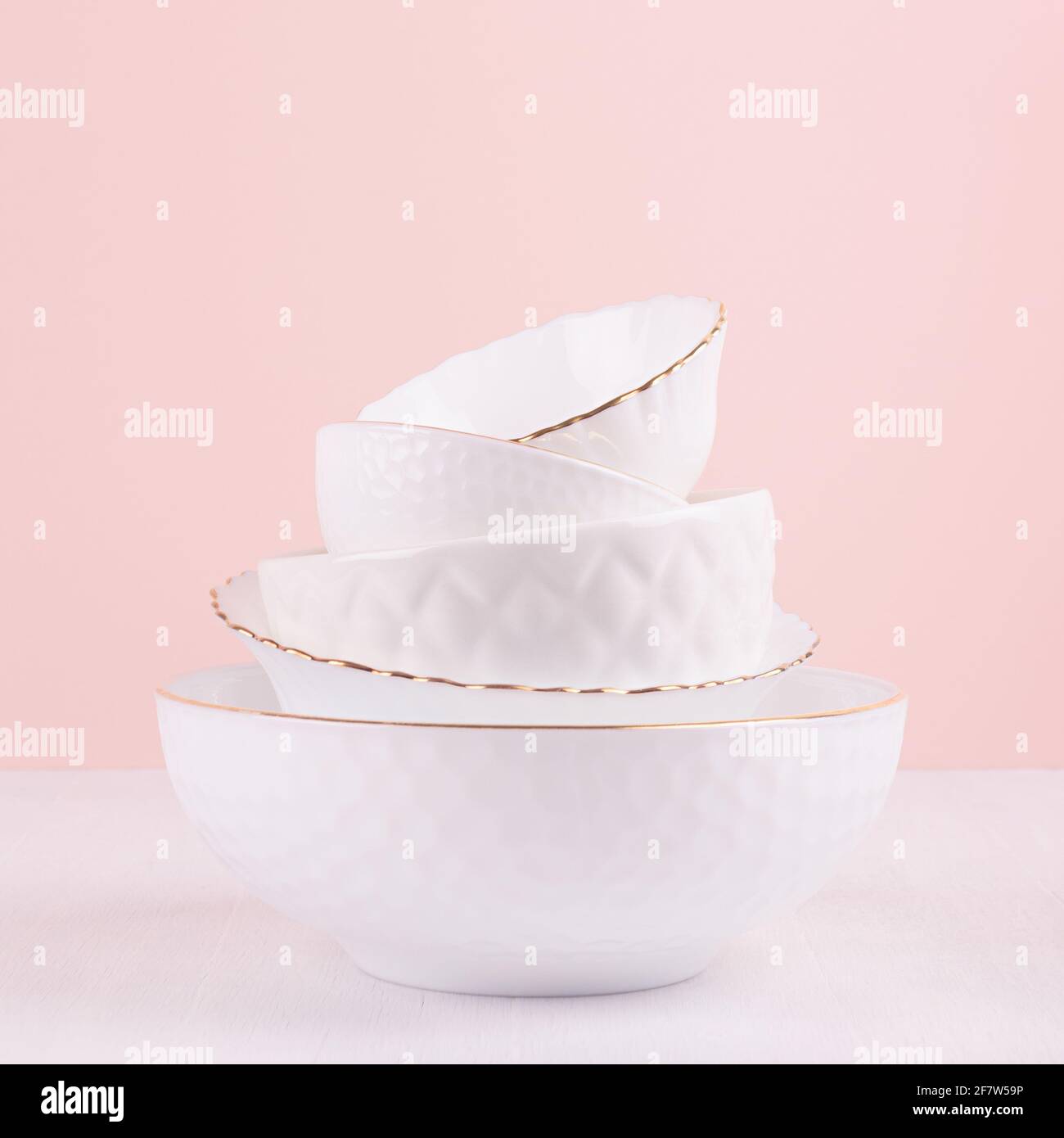 White ceramic crockery with thin gold line, textures in elegant soft ...