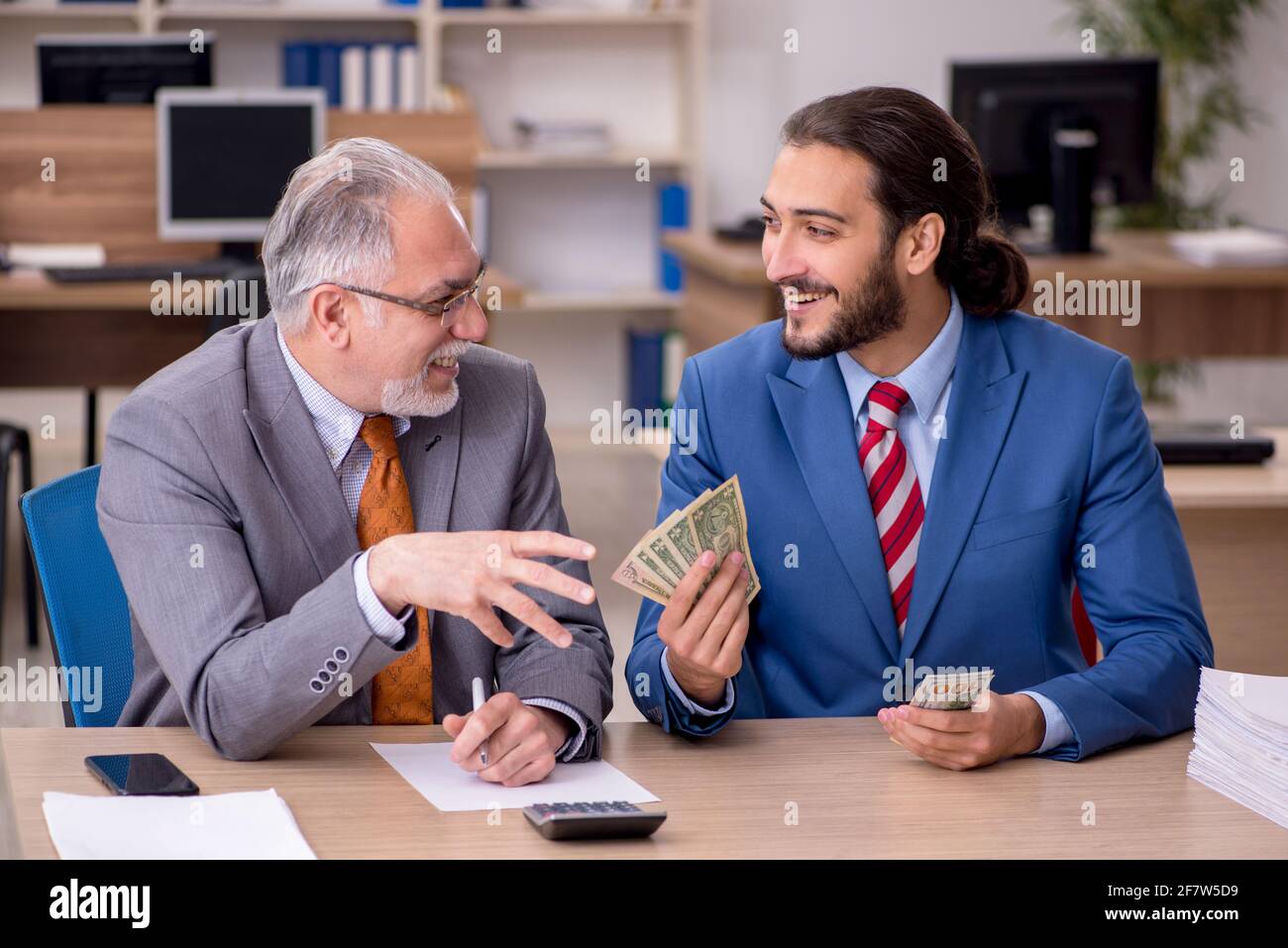 Two employees in remuneration concept Stock Photo - Alamy