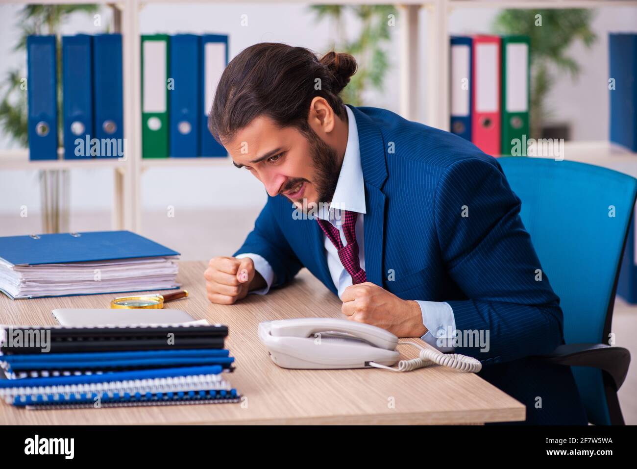 Young employee and too many work in the office Stock Photo - Alamy
