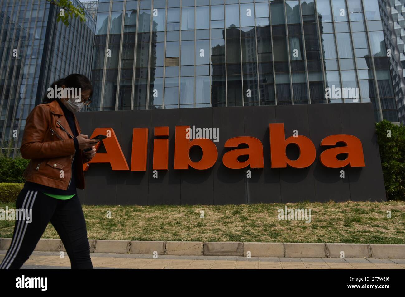 A pedestrian walks past the Alibaba headquarters building in Beijing ...