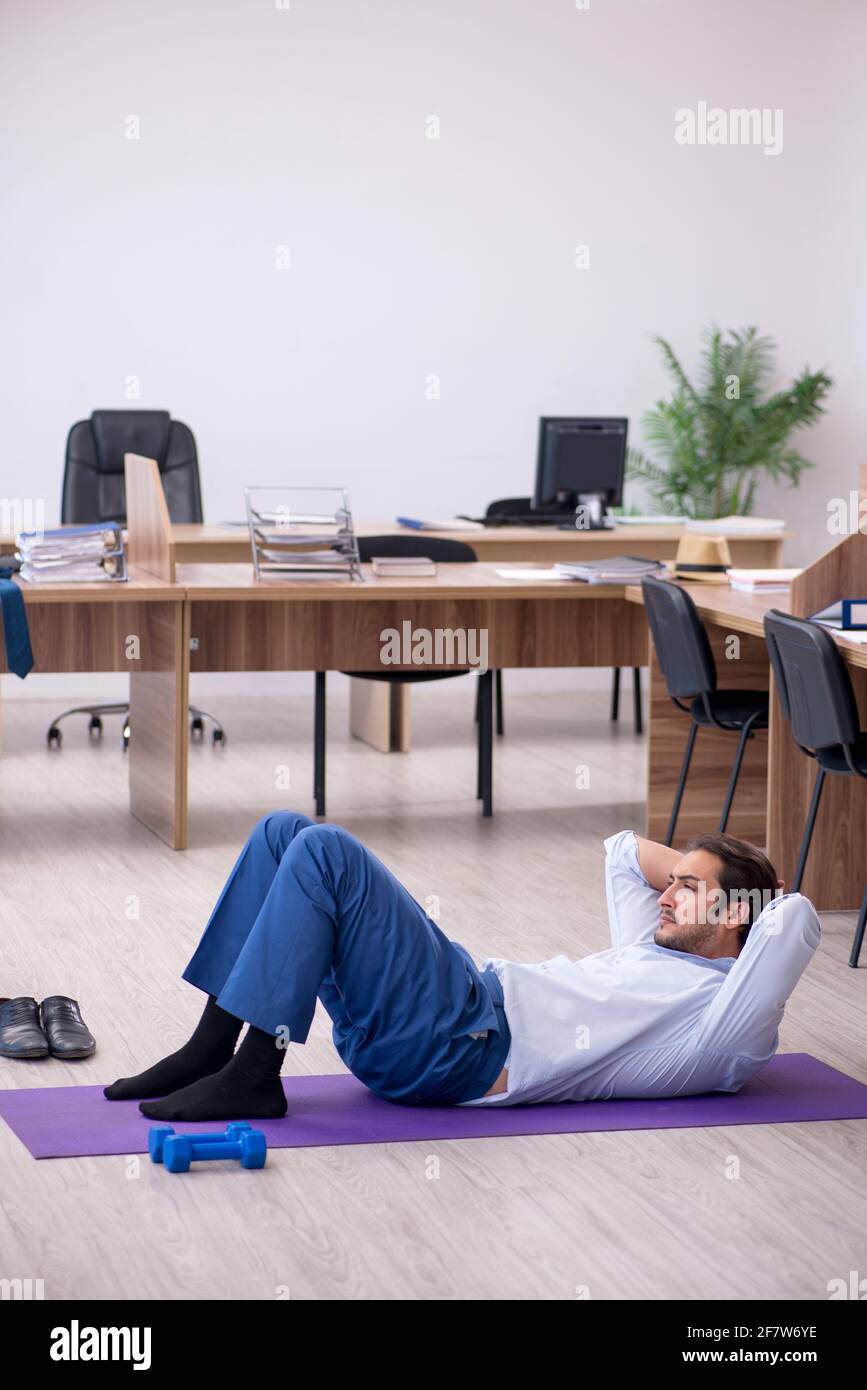 Young employee doing sport exercises during break Stock Photo - Alamy