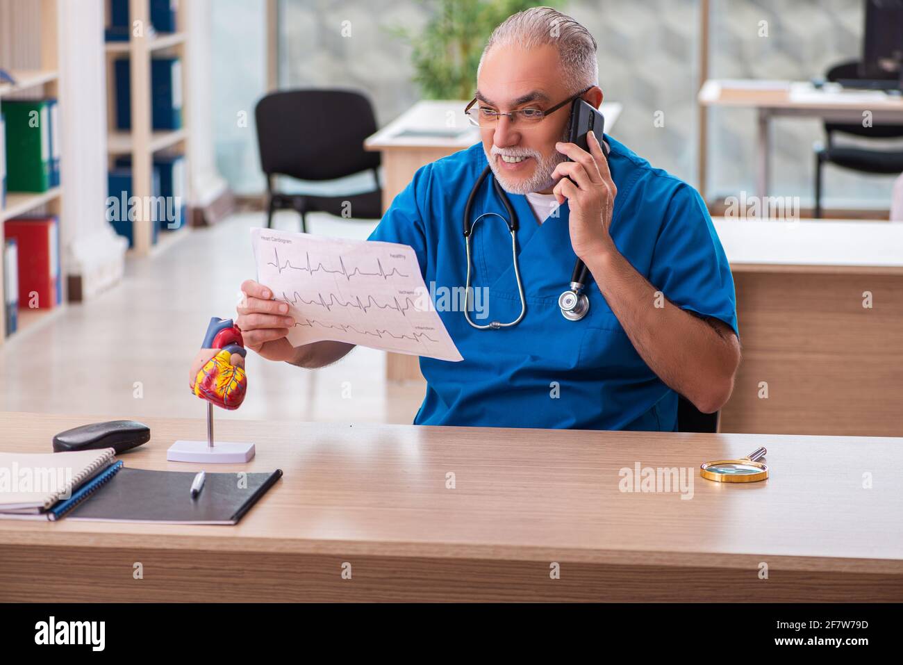 Old doctor cardiologist working in the clinic Stock Photo - Alamy