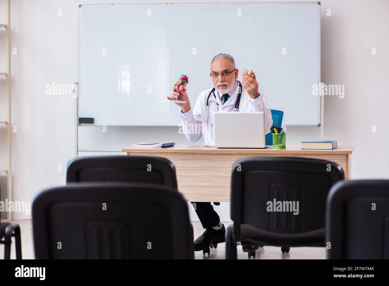 Old doctor lecturer in the classroom during pandemic Stock Photo - Alamy