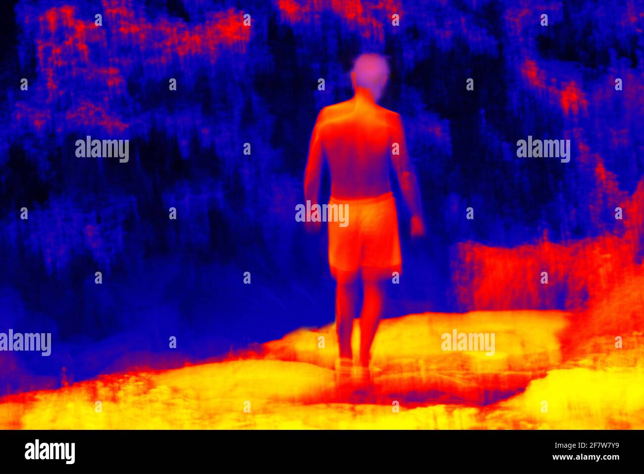Tourist in a tropical park. Scanning the people's body temperature with ...