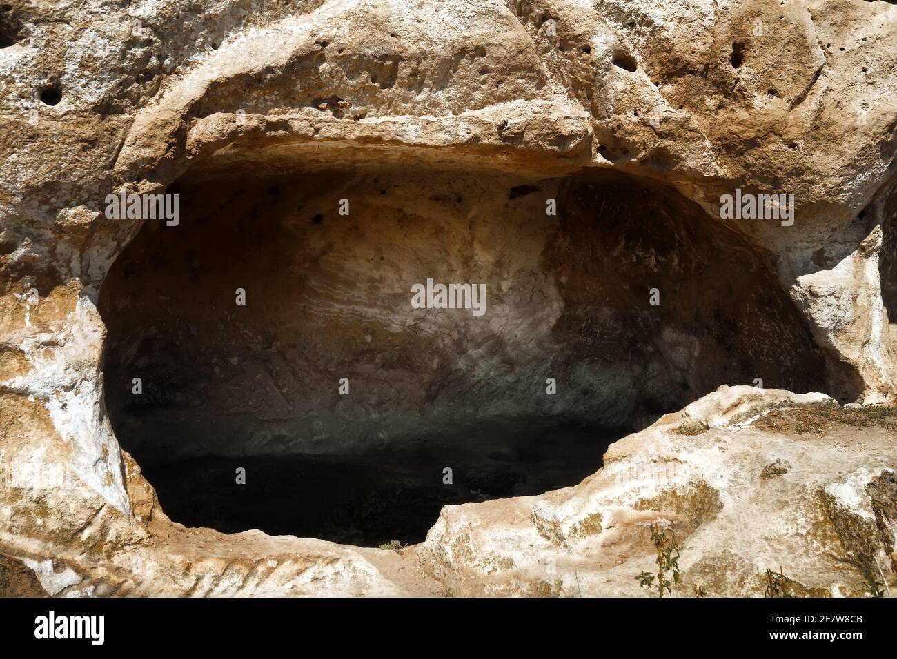 Entrance to a man-made cave in a limestone rock. A place of refuge for ...