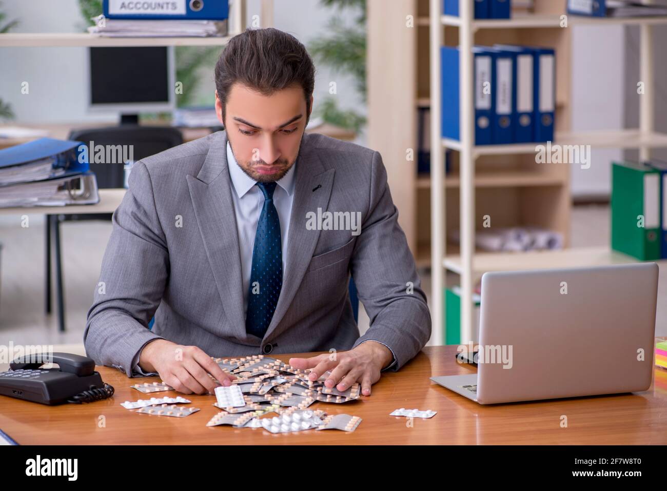 Male sick employee suffering at workplace Stock Photo - Alamy
