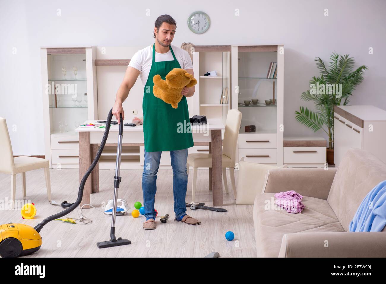 Young contractor cleaning the flat after kids' party Stock Photo - Alamy