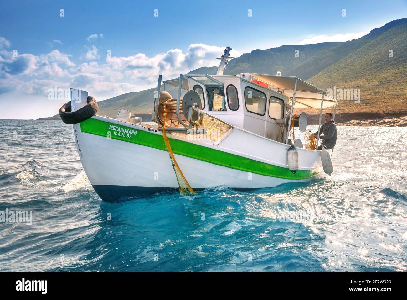 Fisherman is fishing fresh fishes using yellow fishing nets, on fishing ...