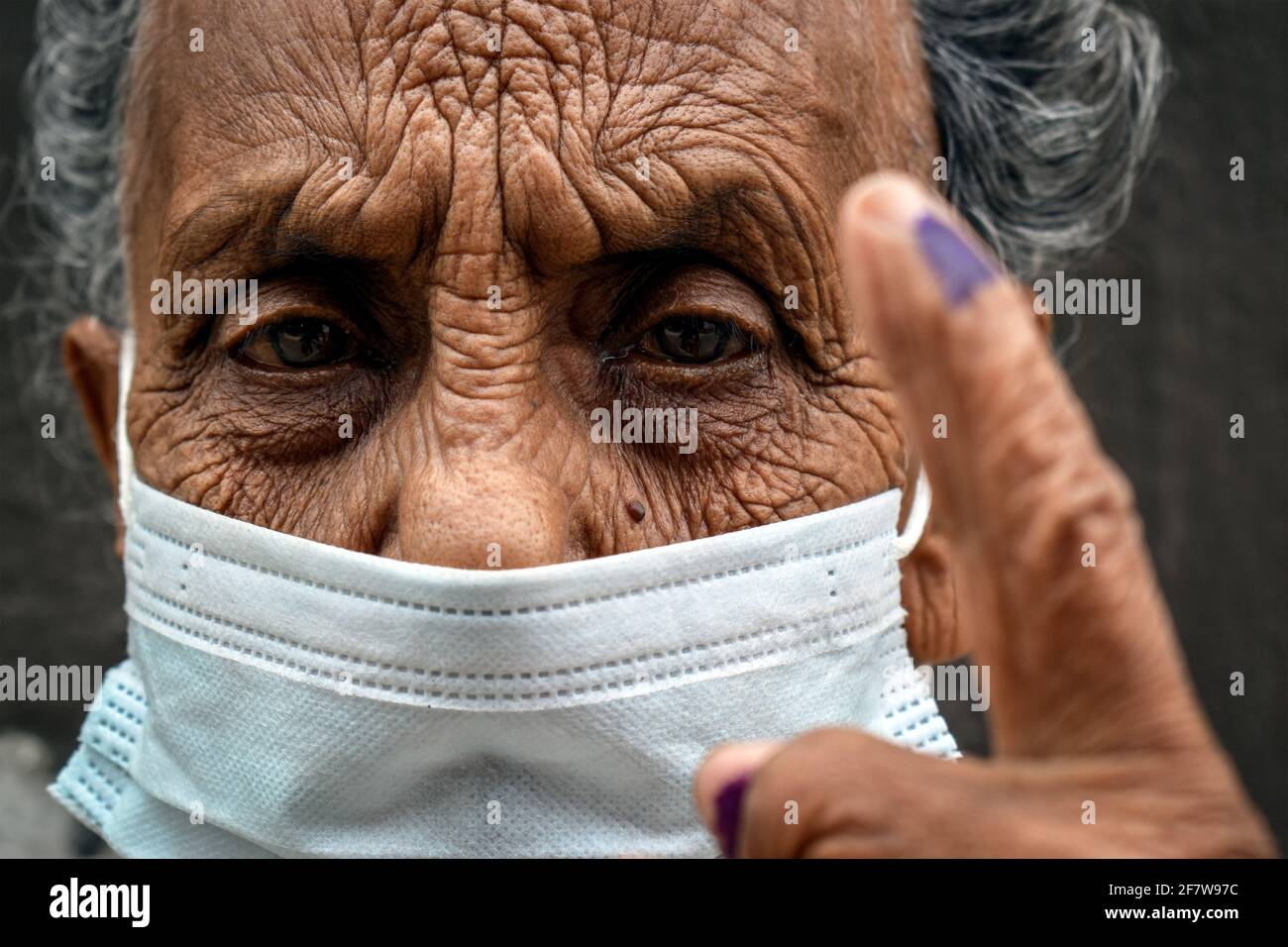 An older woman showing her voting mark after casting her vote during ...