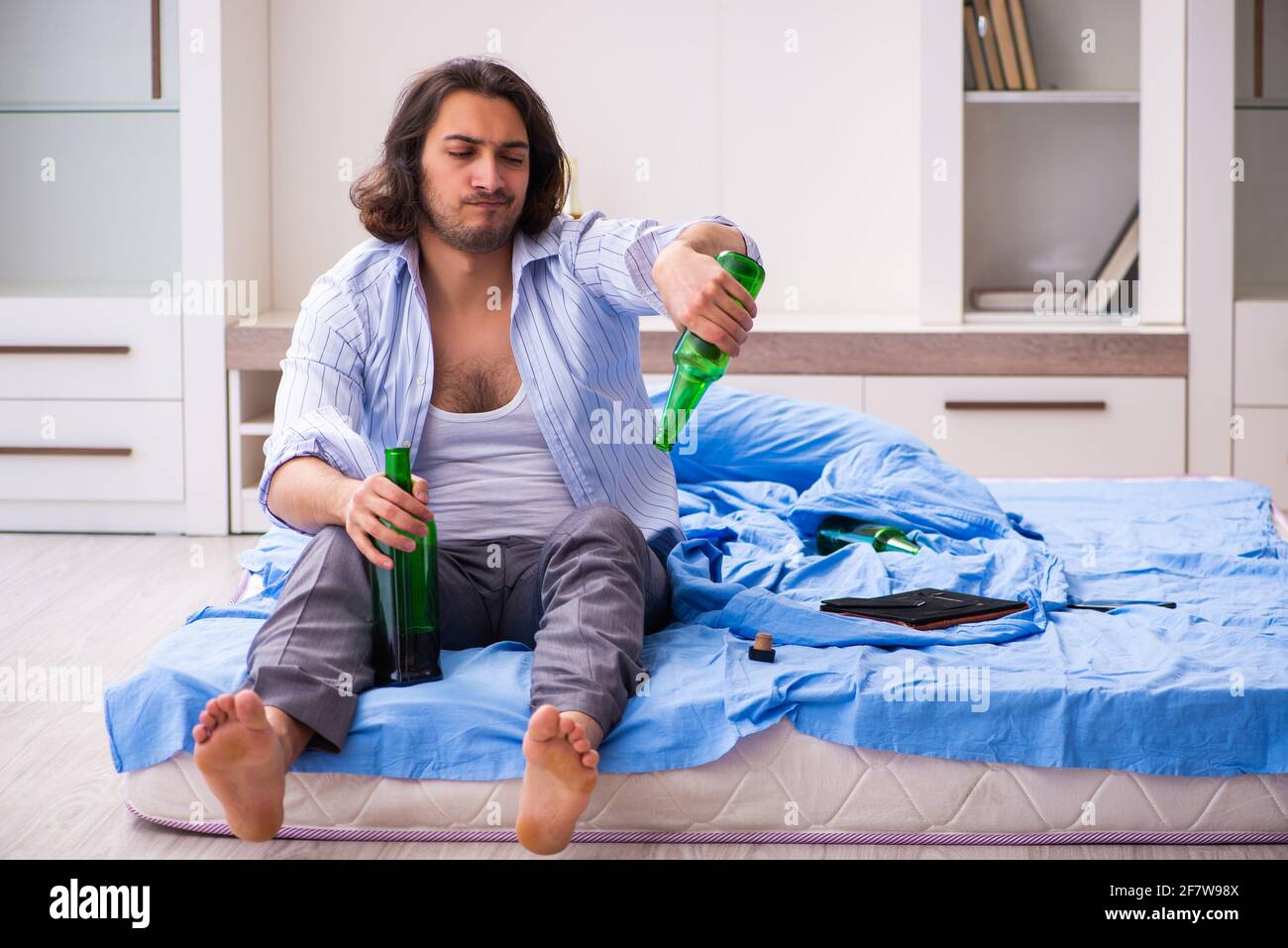 Male alcoholic in the bedroom Stock Photo - Alamy