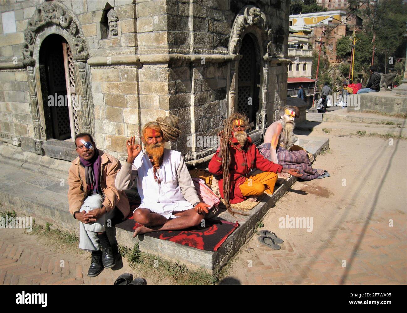 Sacred men showing the peace sign by a temple near the Ganges River in ...