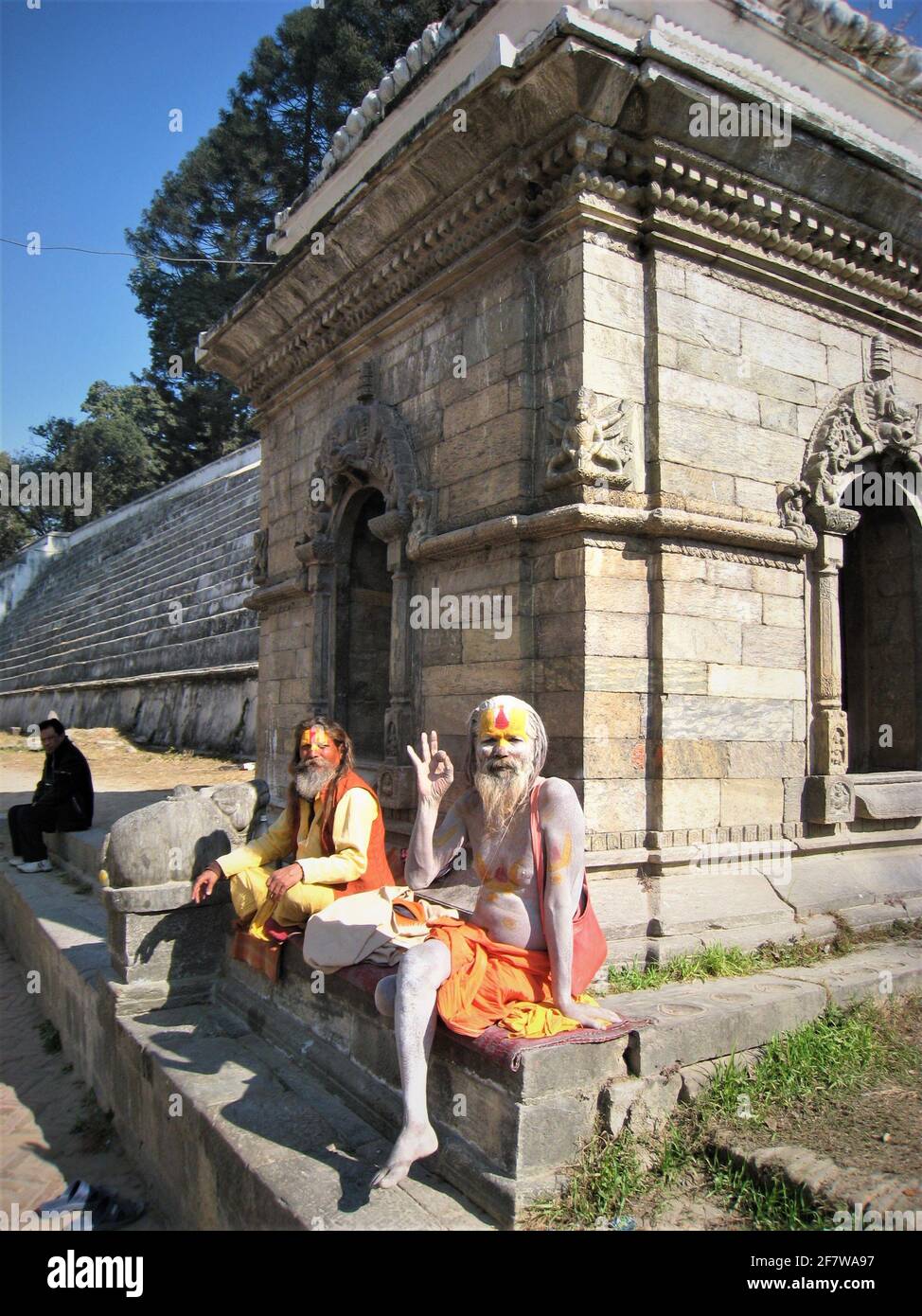 Sacred men showing the peace sign by a temple near the Ganges River in ...
