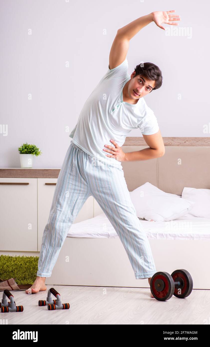 The young man doing morning routine in bedroom Stock Photo - Alamy