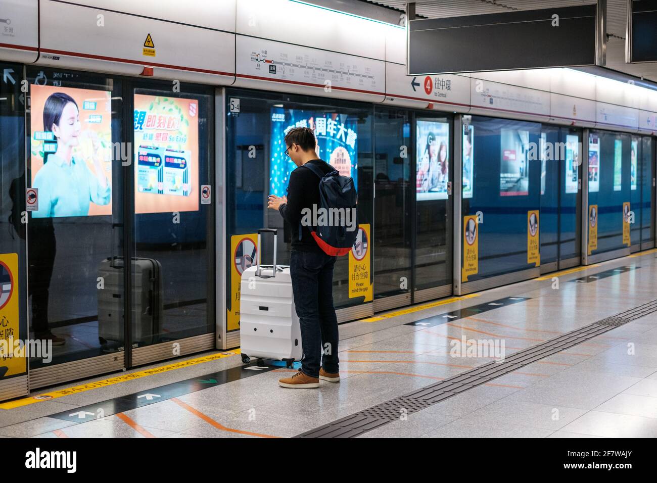 Hong Kong, China - November, 2019: Young asian man with luggage looking ...