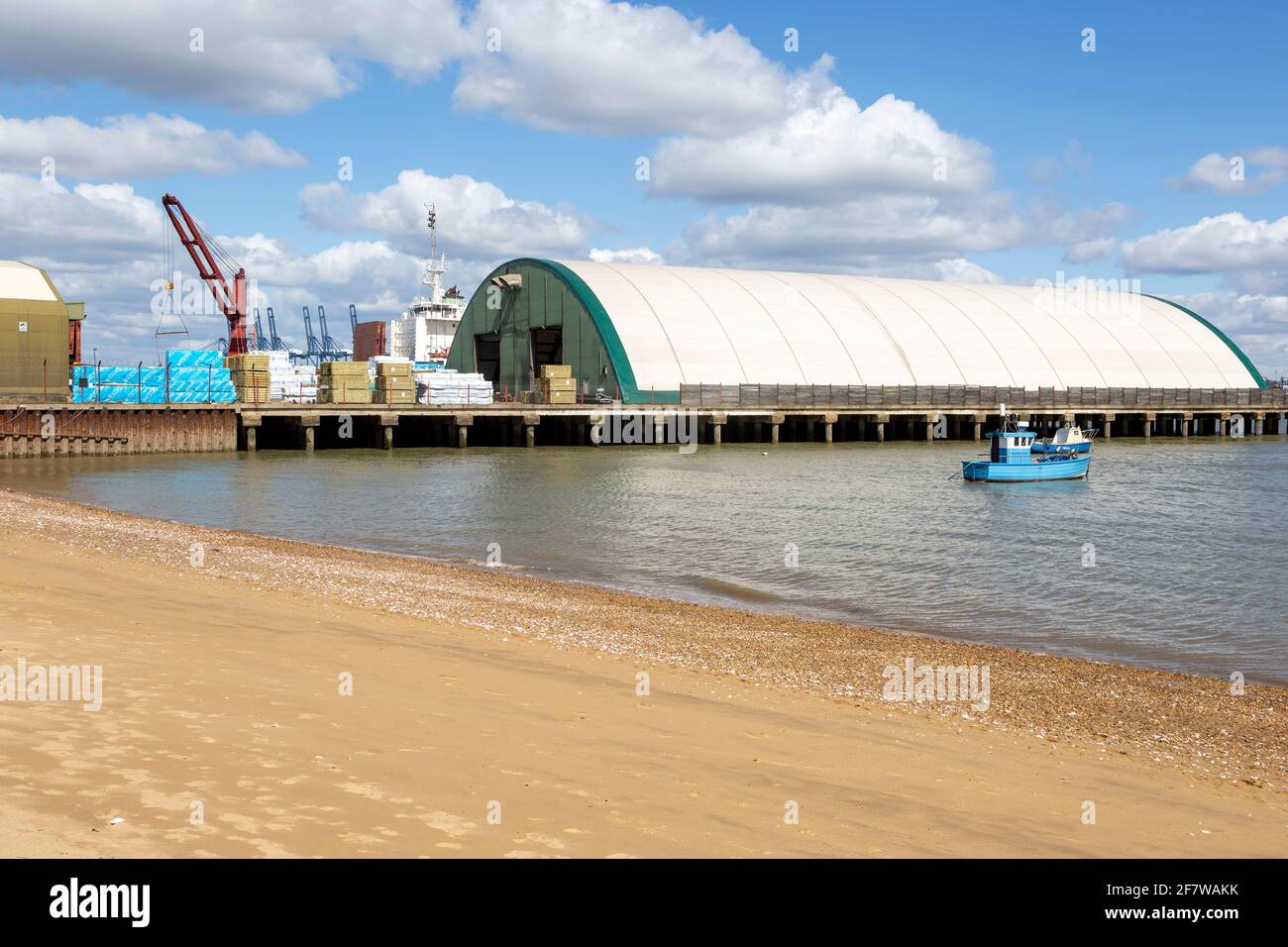 Warehouse dockyard building, small boats sandy beach foreground ...