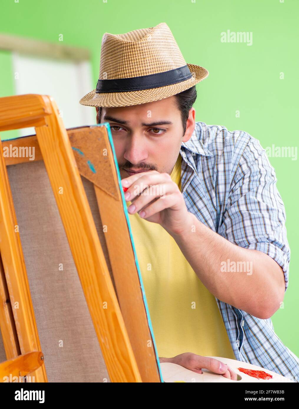 The young male artist working on new painting in his studio Stock Photo ...
