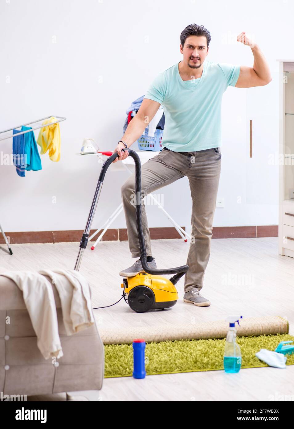 The young man husband doing vacuuming at home Stock Photo - Alamy