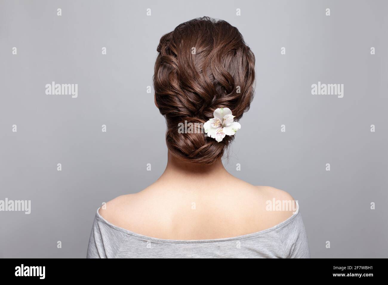Beautiful woman back and head with perfect hairdo and white flower on ...