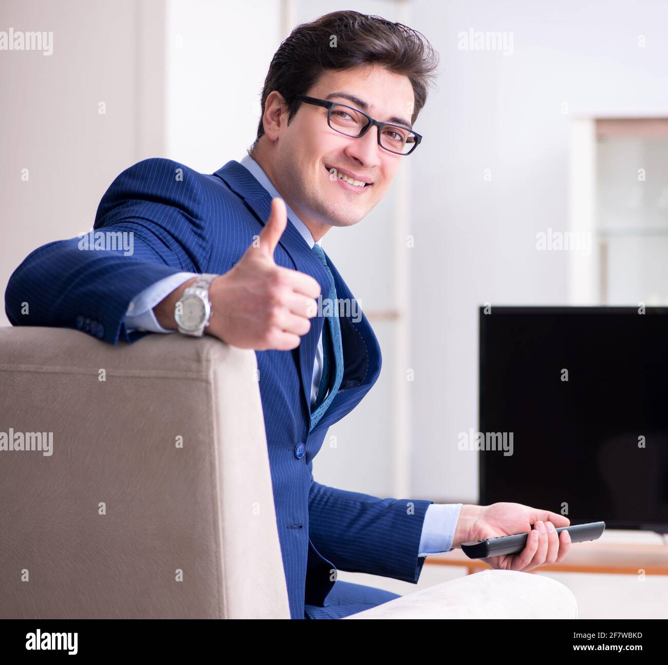 The businessman watching tv in the office Stock Photo - Alamy
