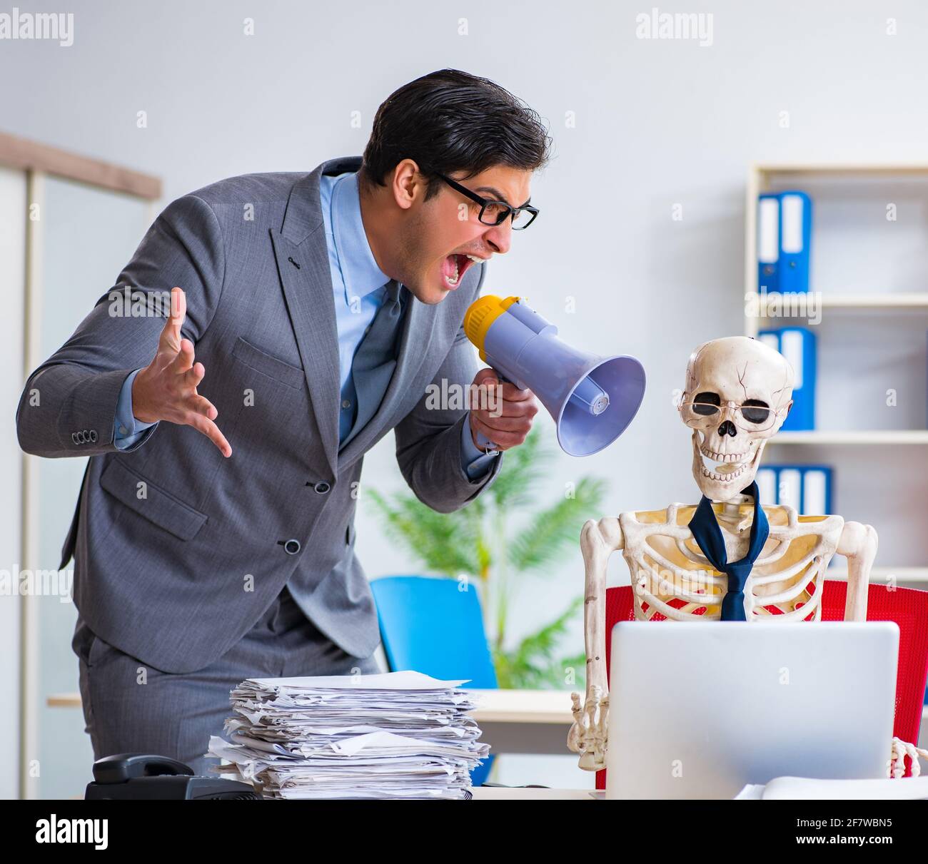 The angry boss yelling at his skeleton employee Stock Photo - Alamy