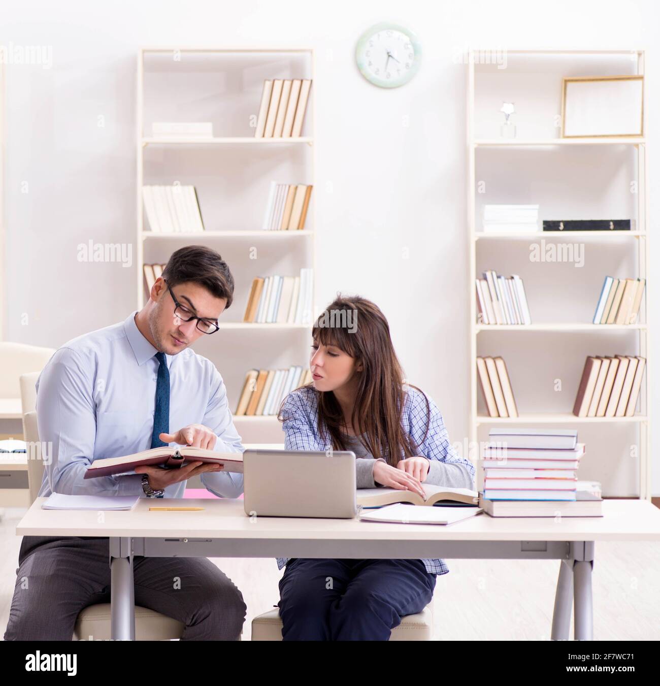 The male lecturer giving lecture to female student Stock Photo - Alamy