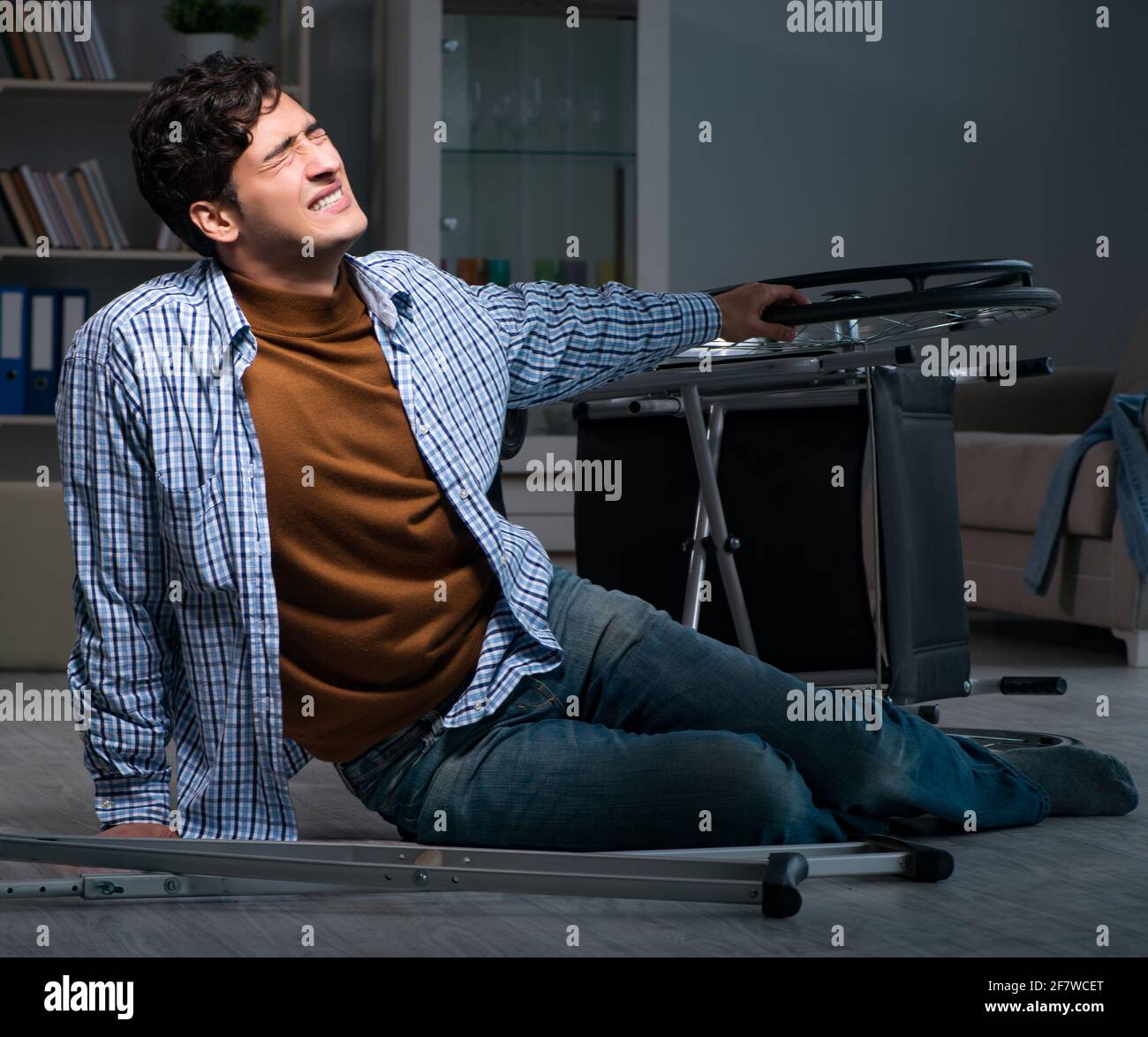 The man fell off wheelchair sitting on the floor Stock Photo - Alamy