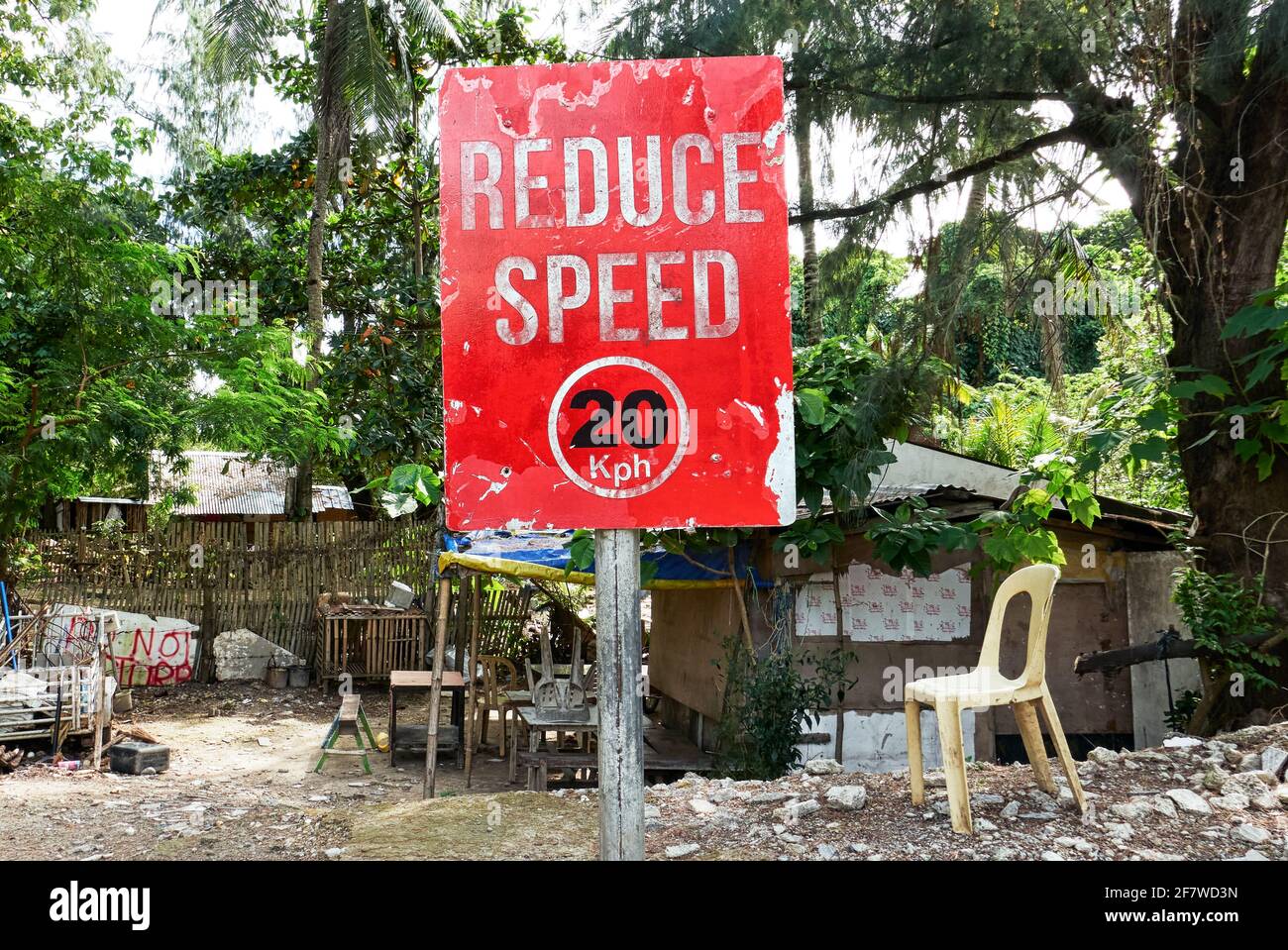 Bright red colored Reduce Speed road signage standing in front of a ...