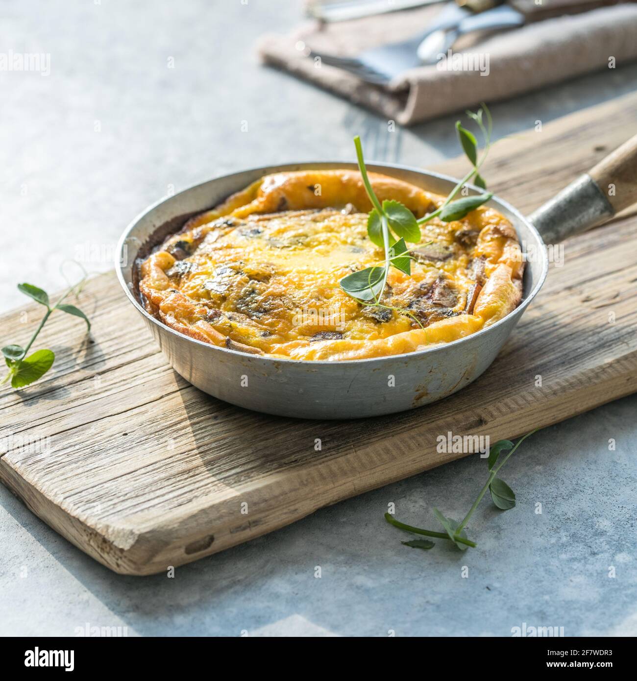 Omlet with mushrooms in a pan on a concrete background. Fritata is an ...