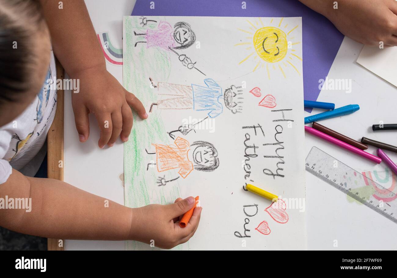 Detail shot of the hands of two girls making by hand some drawings and ...