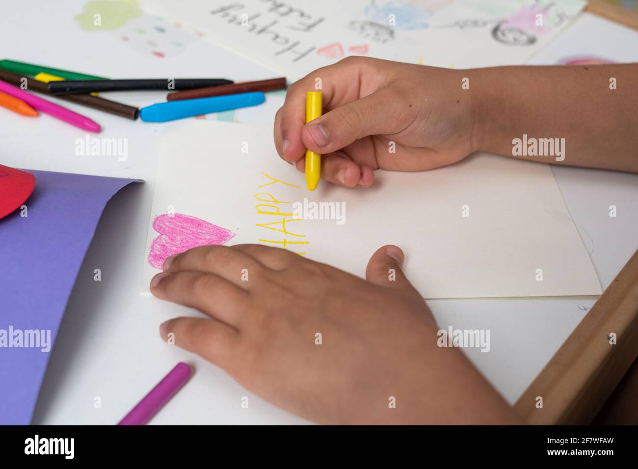 Detail shot of the hands of two girls making by hand some drawings and ...