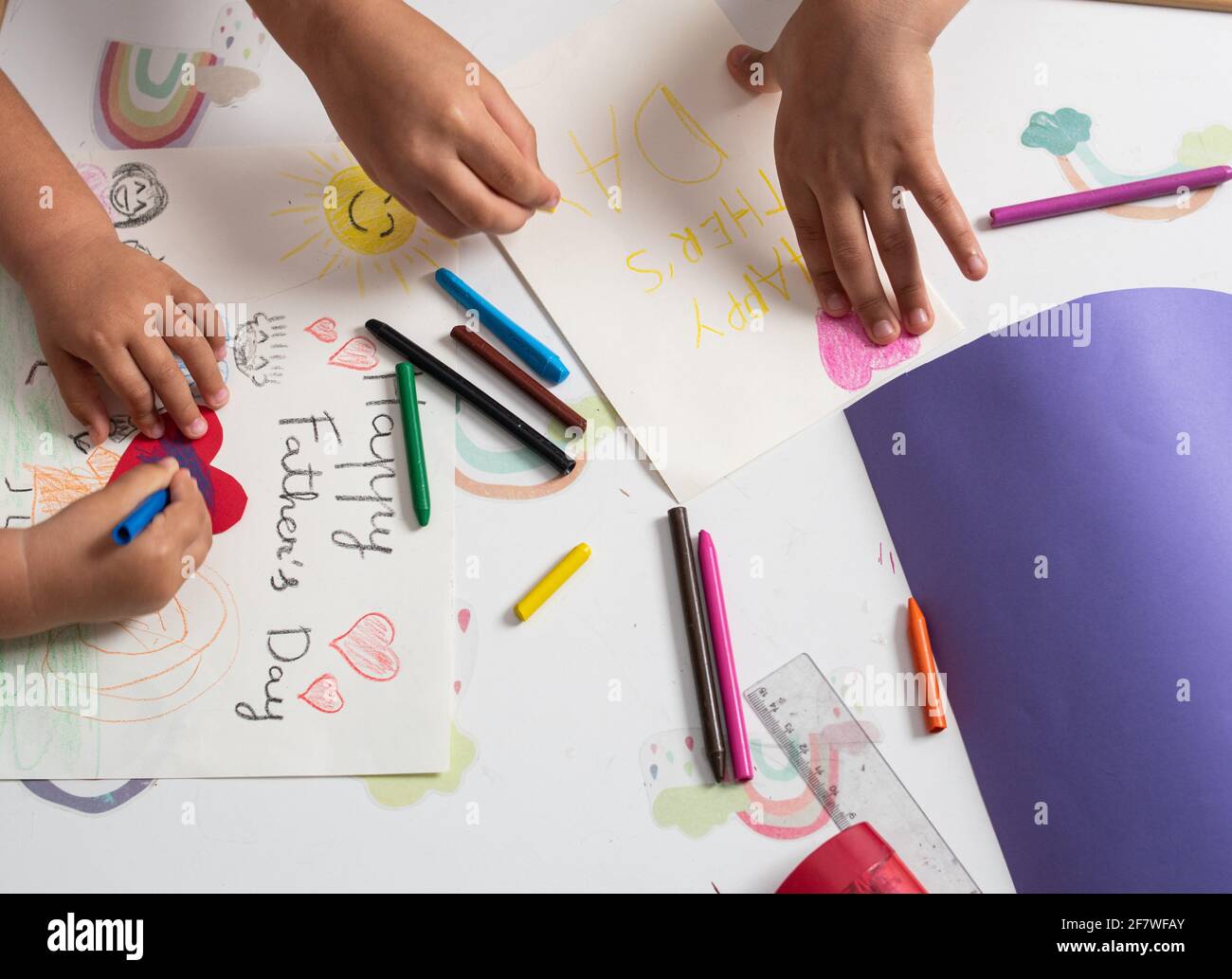 Detail shot of the hands of two girls making by hand some drawings and ...