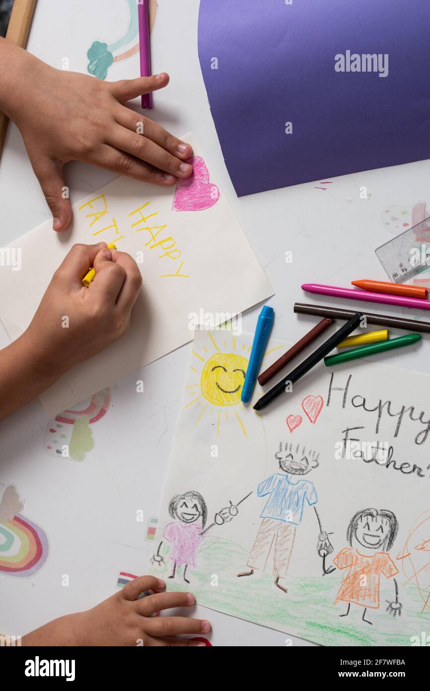 Detail shot of the hands of two girls making by hand some drawings and ...