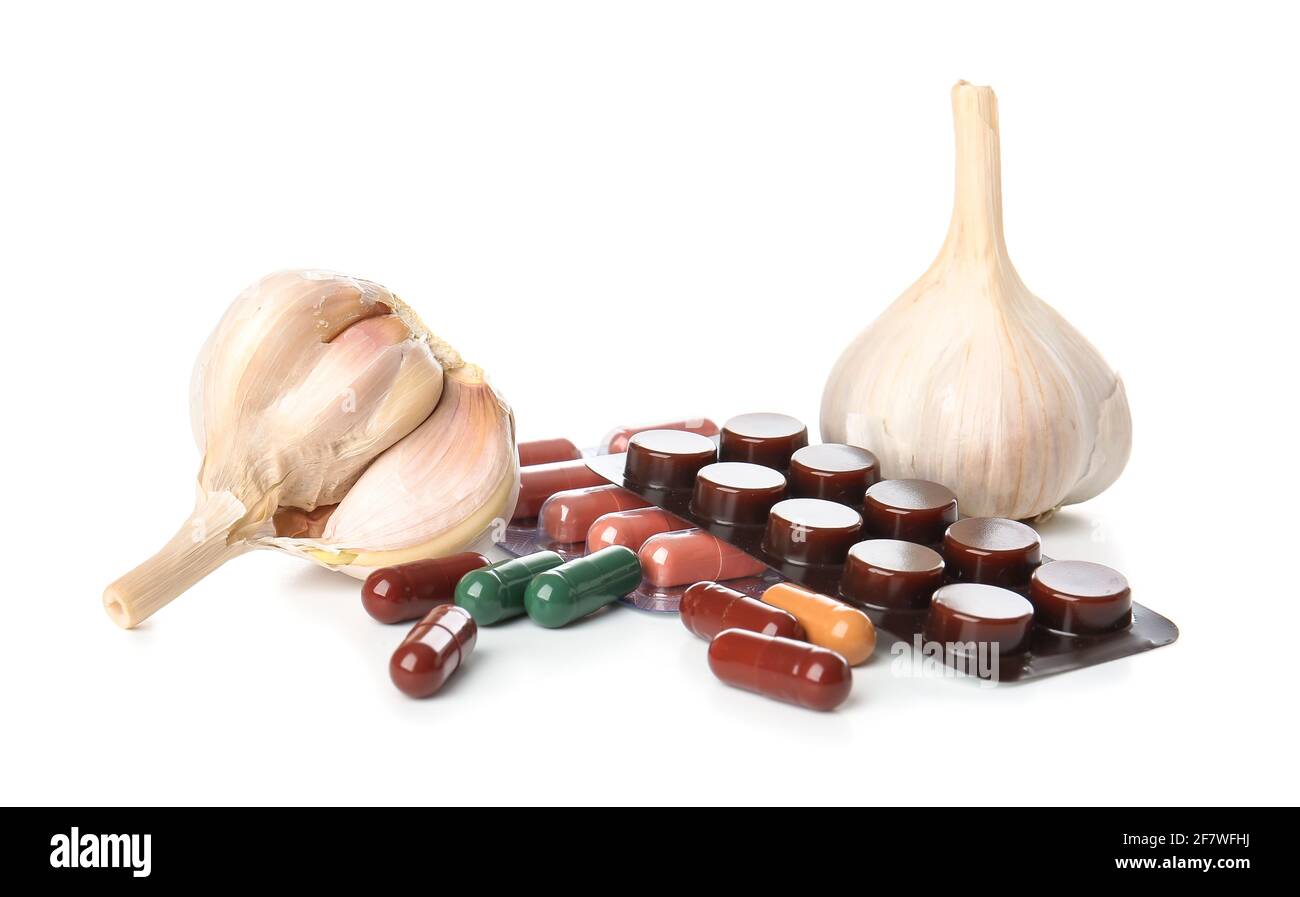 Fresh garlic with pills on white background Stock Photo - Alamy
