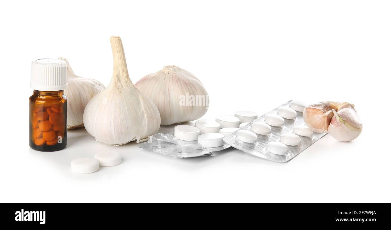 Fresh garlic with pills on white background Stock Photo - Alamy