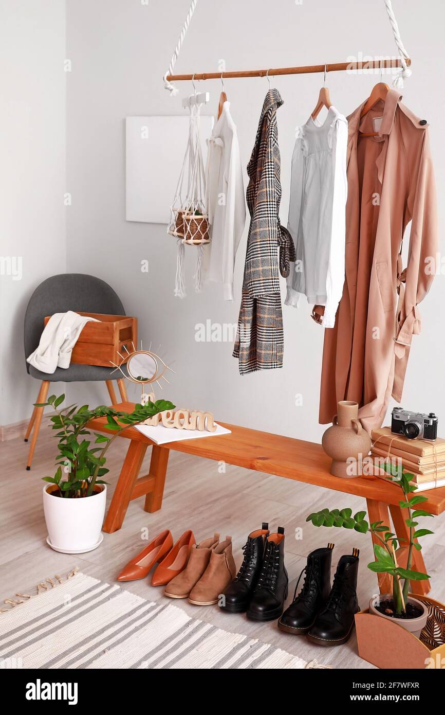 Rack with clothes in interior of modern room Stock Photo - Alamy