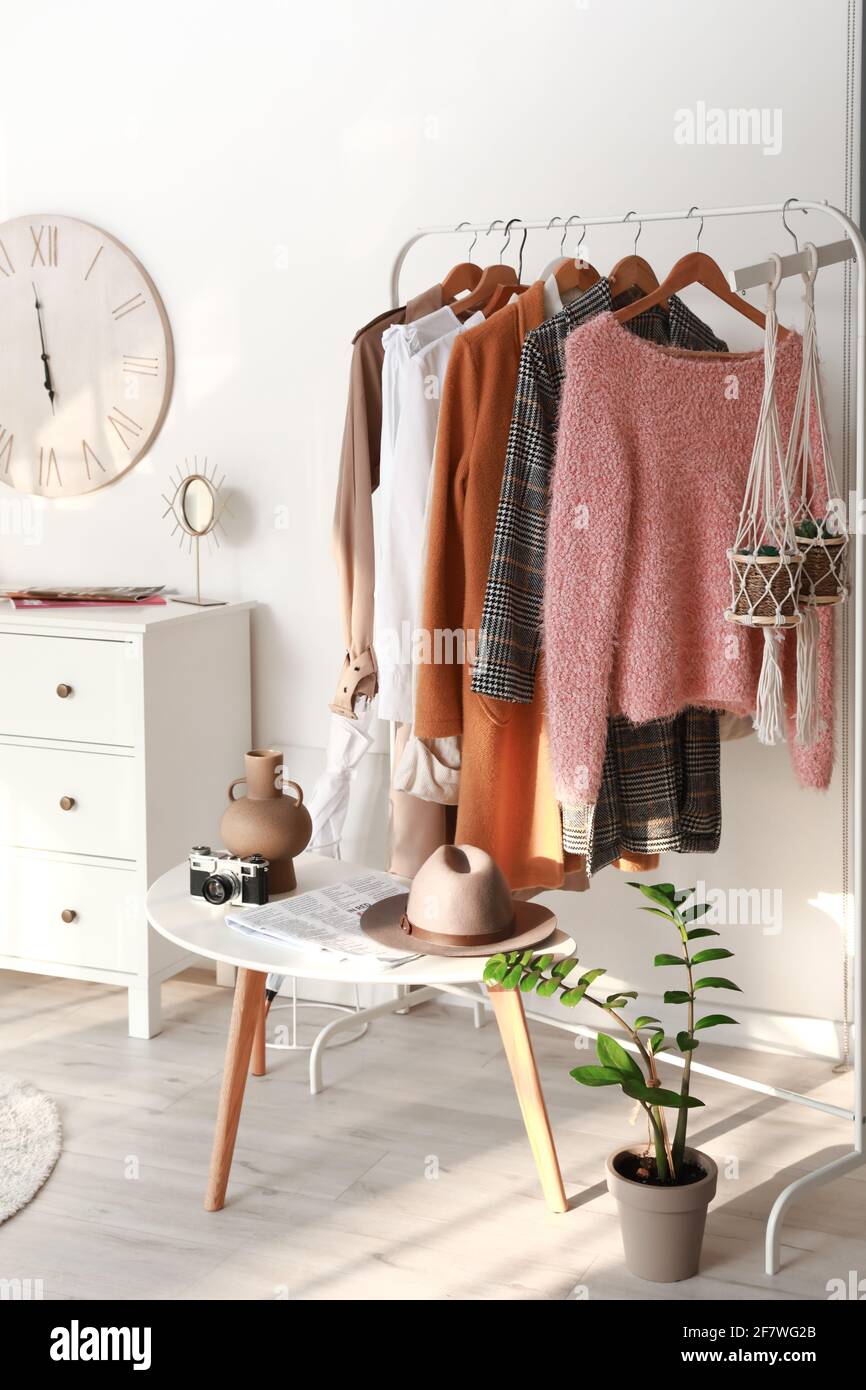 Rack with clothes in interior of modern room Stock Photo - Alamy