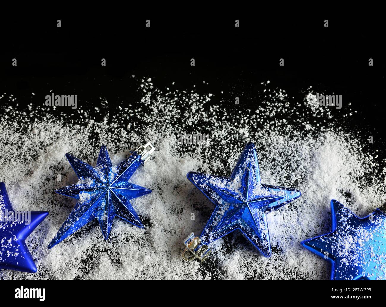 Blue Christmas decorations in the shape star with snow on black ...