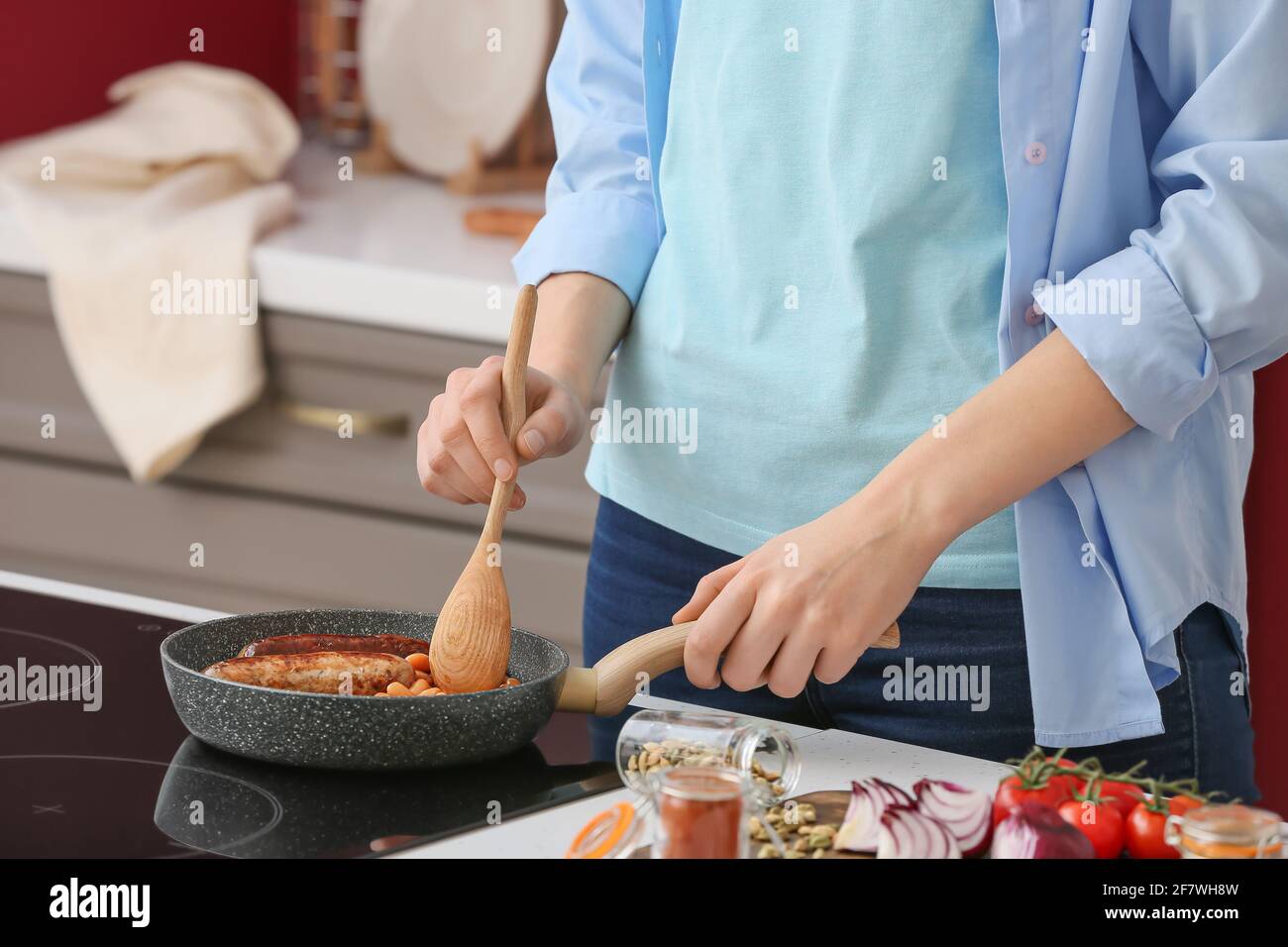 Woman cooking traditional English breakfast on electric stove in ...