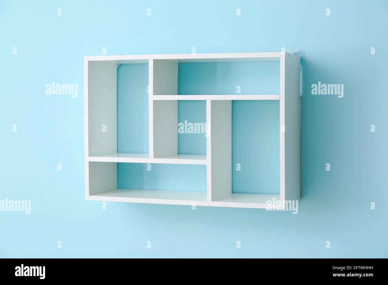 Modern empty shelf hanging on color wall Stock Photo - Alamy