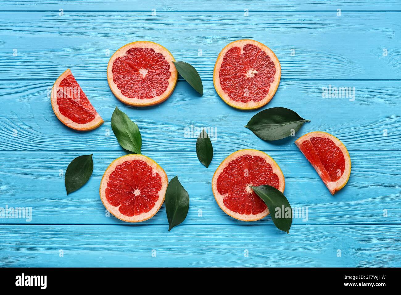 Fresh sliced grapefruit on color wooden background Stock Photo - Alamy