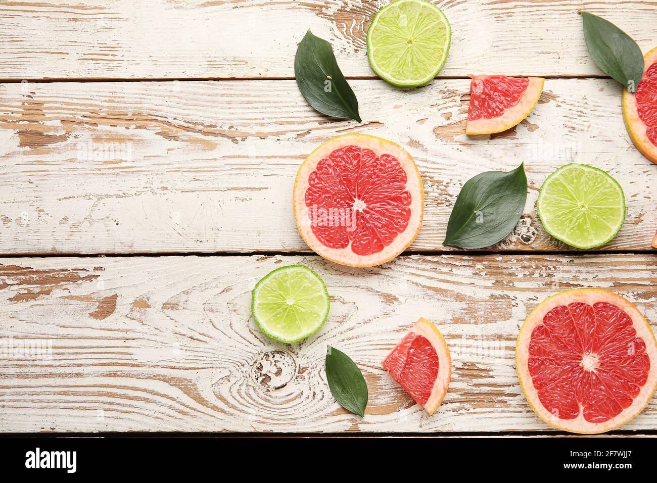 Fresh sliced grapefruit and lime on light wooden background Stock Photo ...