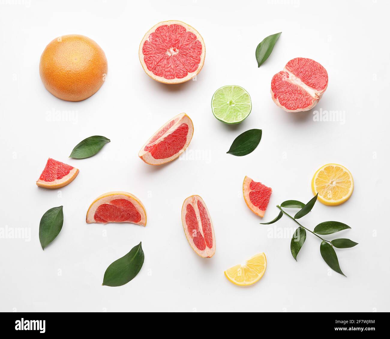 Fresh cut citrus fruits on white background Stock Photo - Alamy