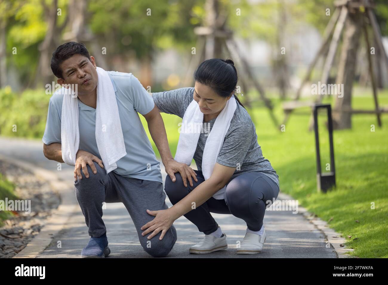 Asian elderly or senior man accident falling down on floor in the park ...