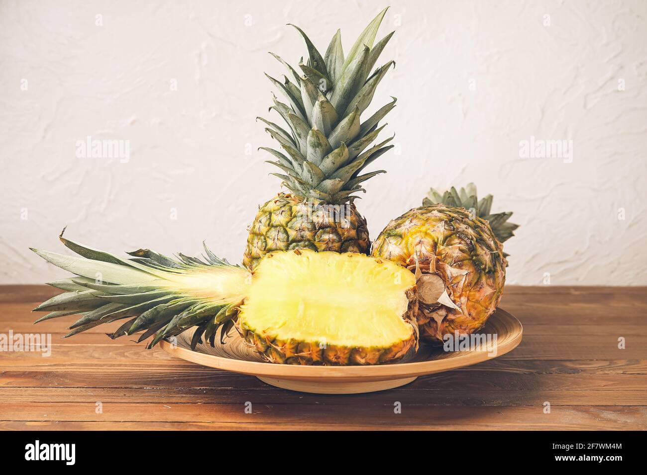 Plate with fresh pineapples on table Stock Photo - Alamy