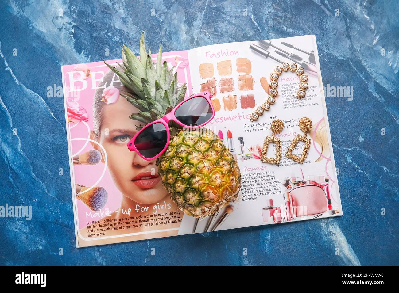 Pineapple with female accessories and fashion magazine on color ...
