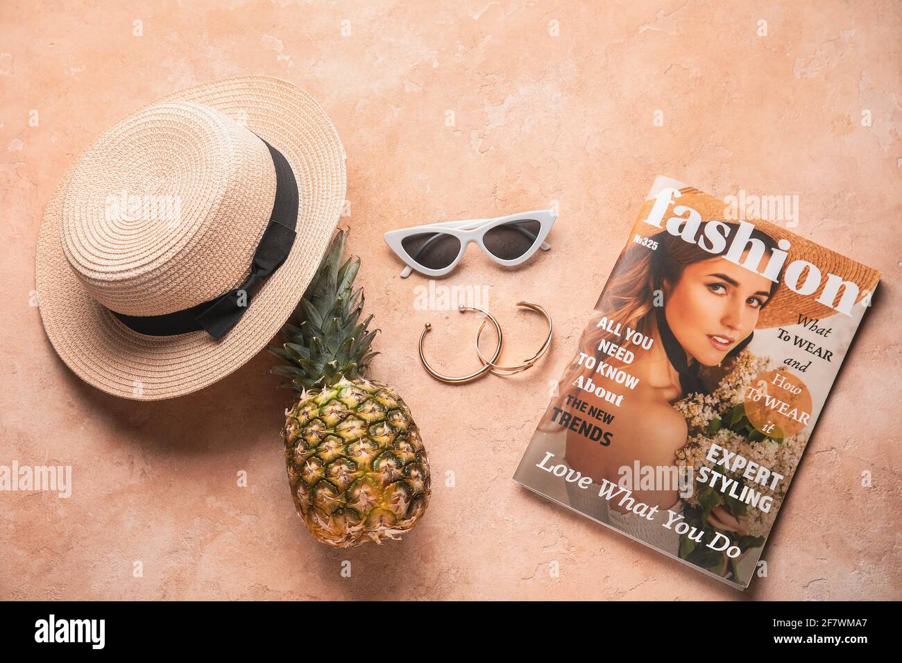 Pineapple with female accessories and fashion magazine on color ...