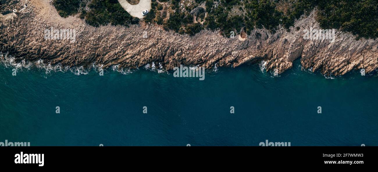 Aerial top view of sea waves hitting rocks on the beach with turquoise ...