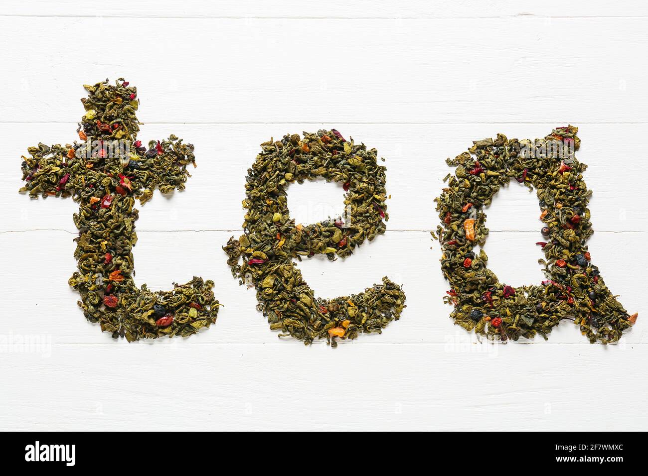 Word TEA made of dry green leaves on white wooden background Stock ...